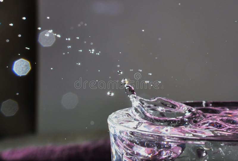 A Drop Splashing in Purple Water, Falling into the Water on a White ...