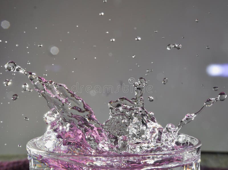 A Drop Splashing in Purple Water, Falling into the Water on a White ...