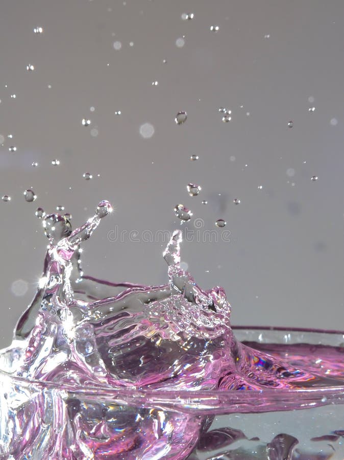 A Drop Splashing in Purple Water, Falling into the Water on a White ...
