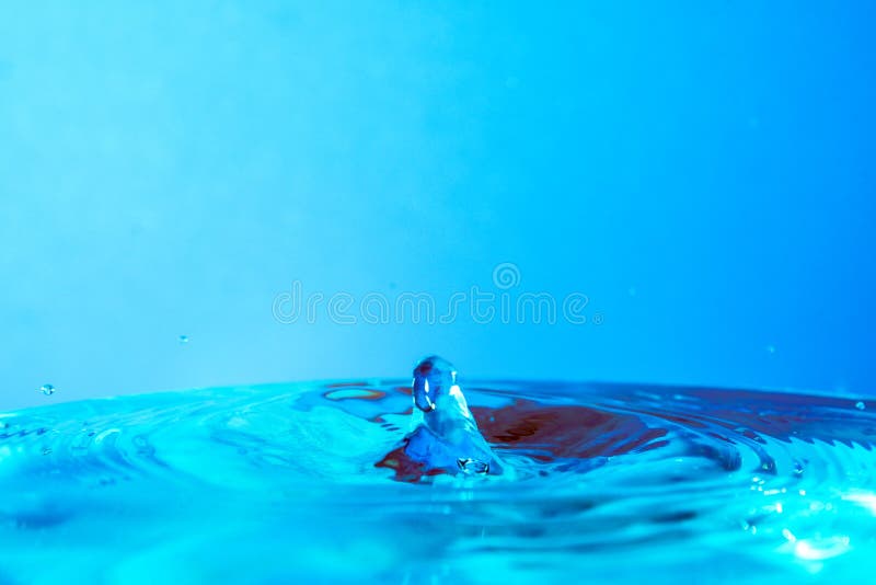 Drop of Water Falling in Blue Water and Blue Background. Stock Photo ...