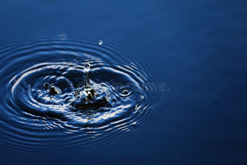 A Drop of Water Falls into the Water, Making a Perfect Splash of Drops ...