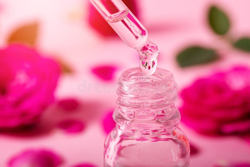 Dropper with Rose Flower Essential Oil Drop Over the Bottle Stock Image ...