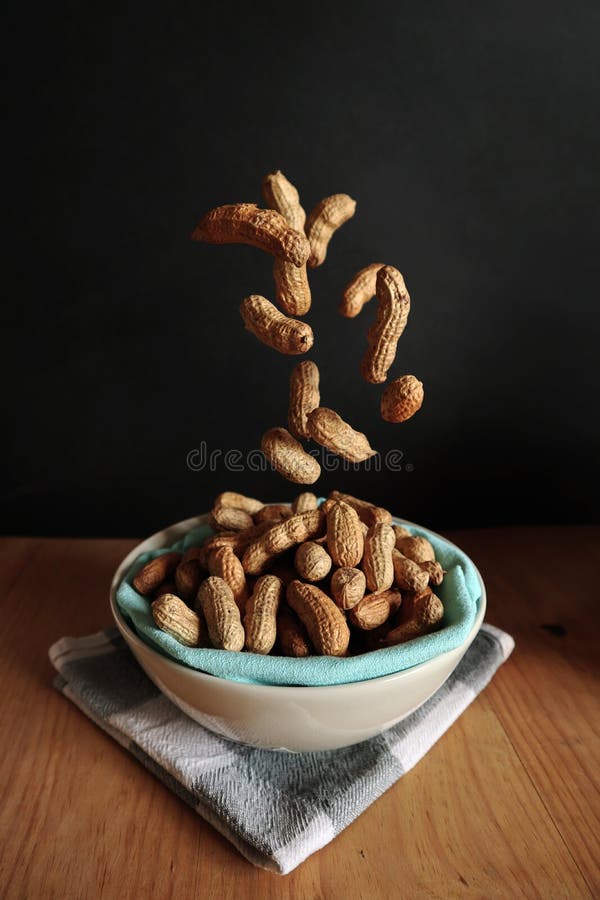Dropping peanuts in a bowl stock photo. Image of nutrient - 207712304