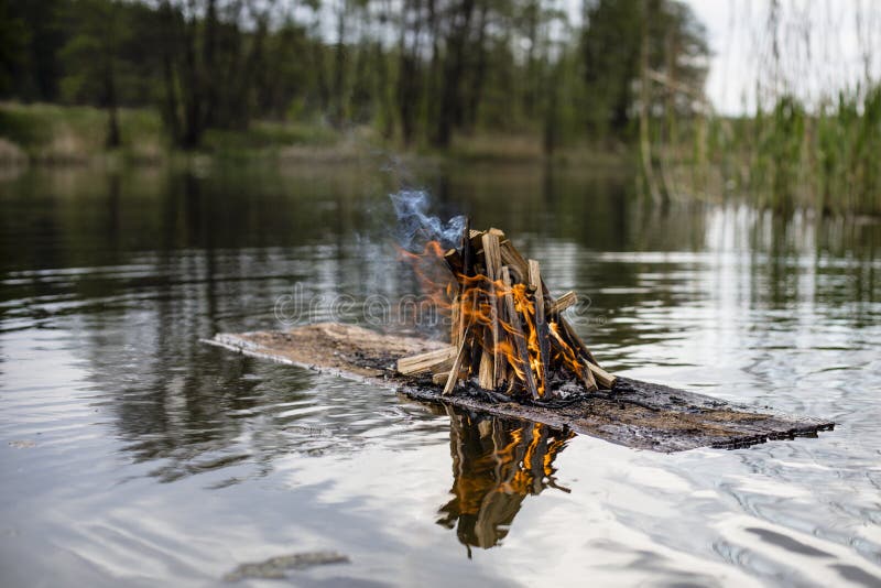 A Raft with a Bright Burning Fire, Floats in the Middle of a River, in ...