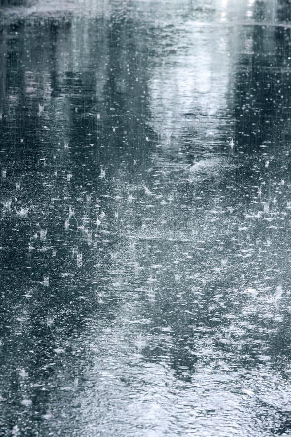 Raindrops Rippling in Water Puddle on Asphalt Sidewalk during Th Stock ...