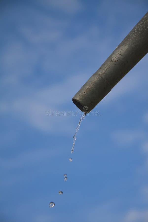 Drops of Water Flowing from Pipe - Close Up with Blue Sky. Concept for ...