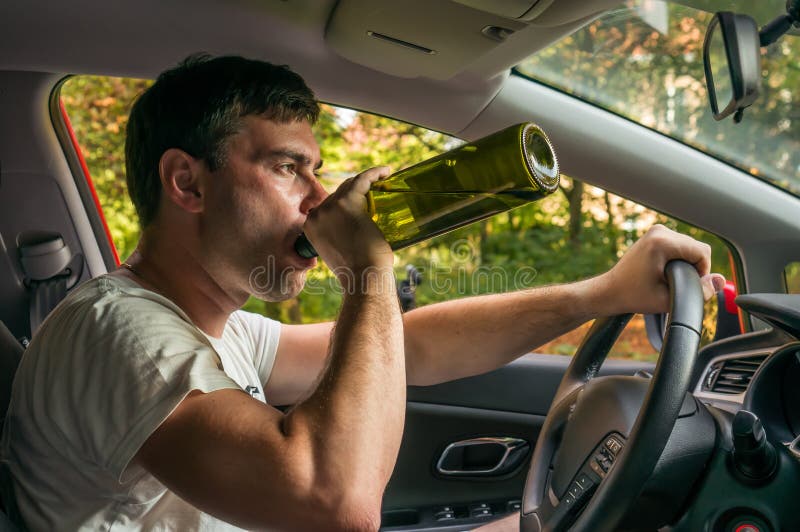Drunk Driver with Bottle of Wine Driving a Car Stock Photo - Image of ...