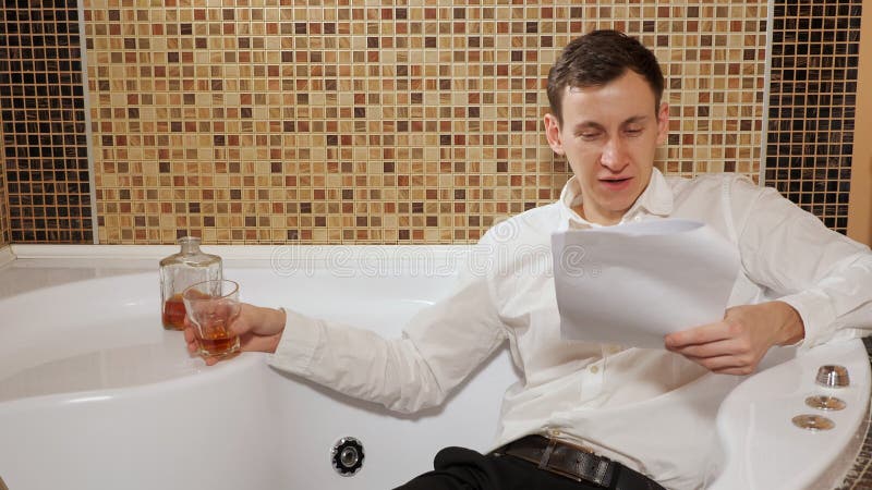 Drunk Man in Trousers and Shirt is Lying in the Bath and Studying ...