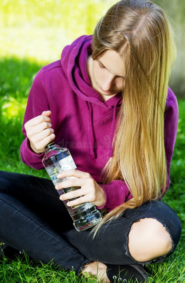 Drunk Young Woman with Bottle of Alcohol Stock Photo - Image of laying ...