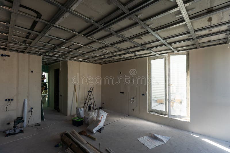 Installation of Drywall. Workers are Using Screws and a Screwdriver To Attach Plasterboard To ...
