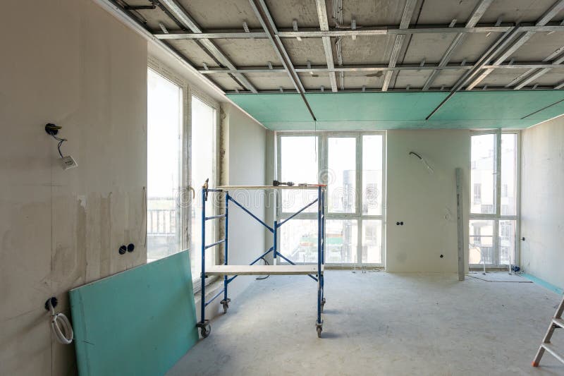 Installation of Drywall. Workers are Using Screws and a Screwdriver To Attach Plasterboard To ...
