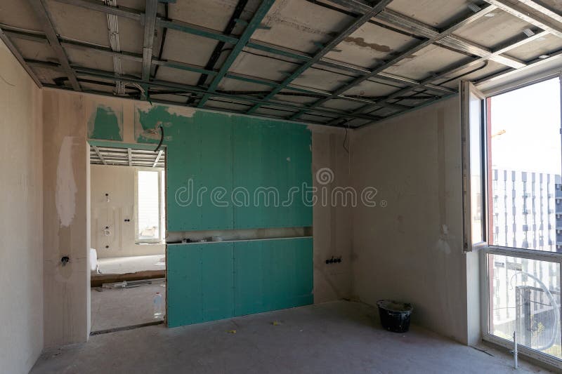 Installation of Drywall. Workers are Using Screws and a Screwdriver To Attach Plasterboard To ...
