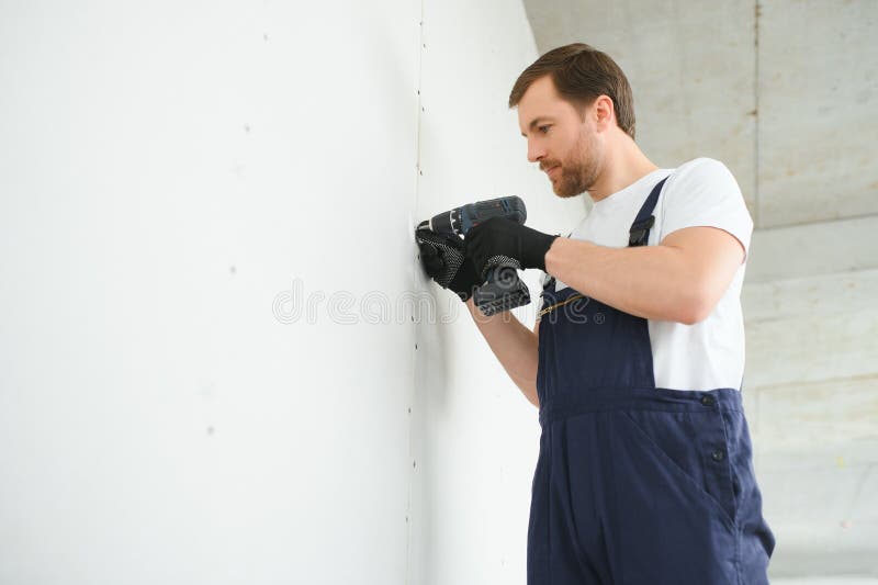 Drywall Worker Works on Building Site in a House. Stock Image - Image ...
