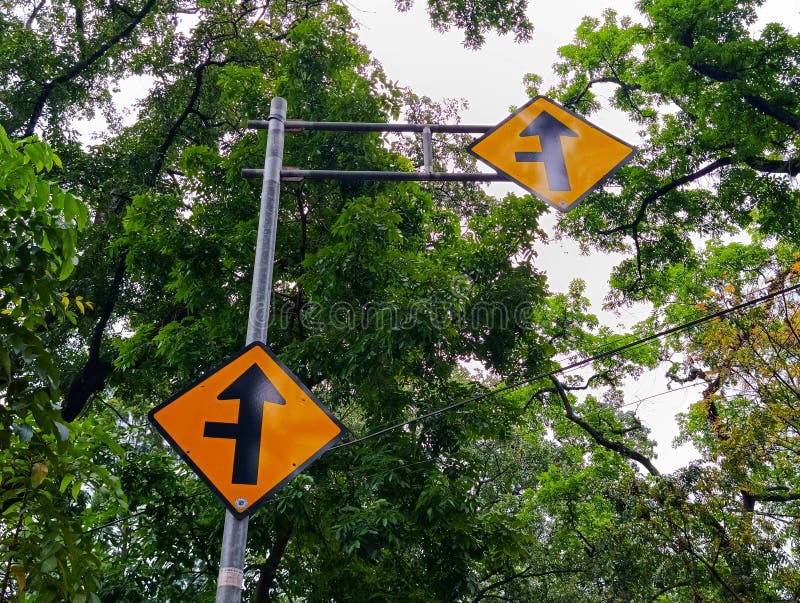 Dual Merge Ahead Road Signs in Greenery Stock Image - Image of merge ...