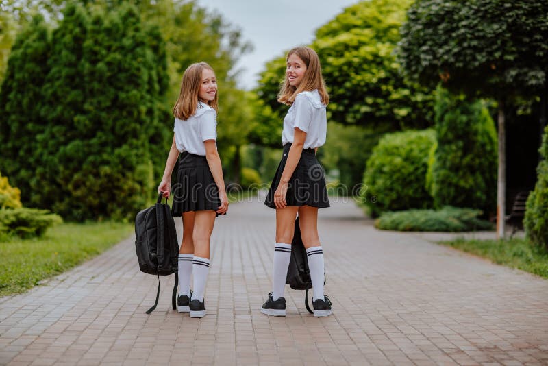 Duas Garotas Bonitas De Uniforme Preto E Branco E Bolsas Indo Para A