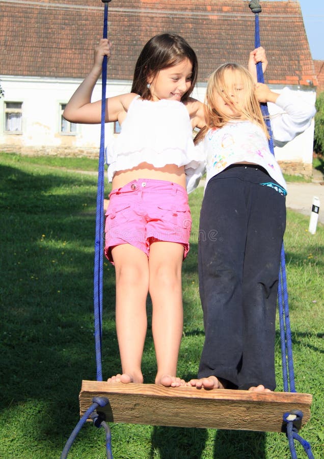 Duas Meninas Que Jogam No Balanço Foto De Stock Imagem De Playground