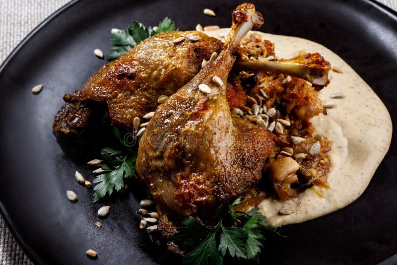 Duck Leg with White Sauce on a Dark Plate Stock Image - Image of duck ...