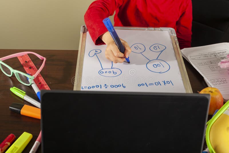 A Kid is Doing a Math Assignment on a Whiteboard during an Online Class ...