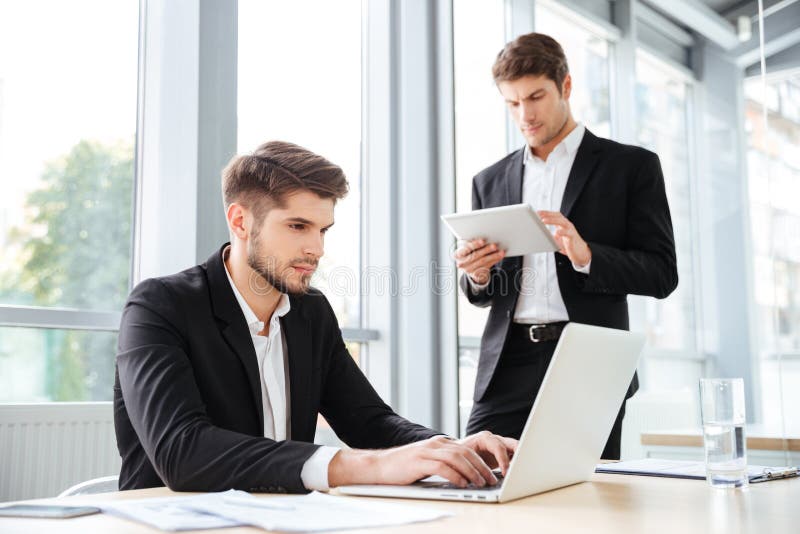 Due Uomini D'affari Che Lavorano Con Il Computer Portatile E La ...