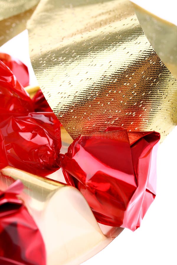 Dulces Rojos Con La Cinta De Oro Aislada En Blanco Foto de archivo ...