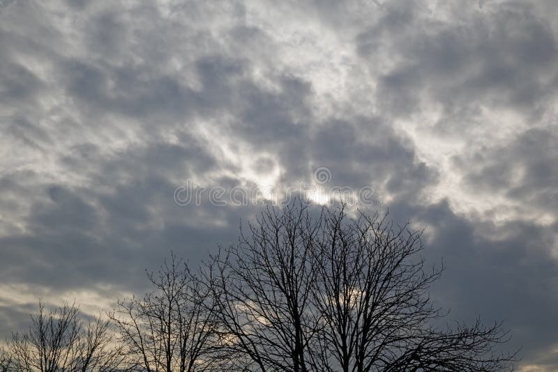 The Dull Winter Sun Hides Behind Dark Clouds Against the Backdrop of ...