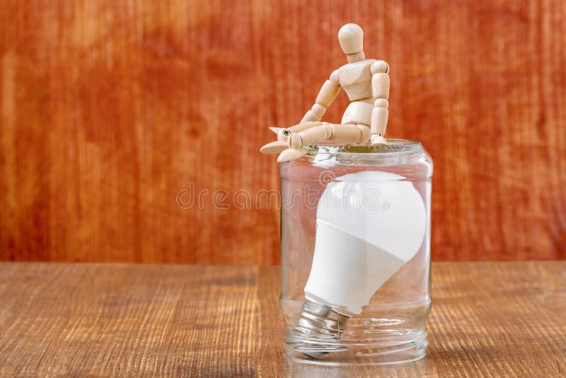 Dummy Sitting on the Glass Jar with a Lightbulb Inside Stock Image ...