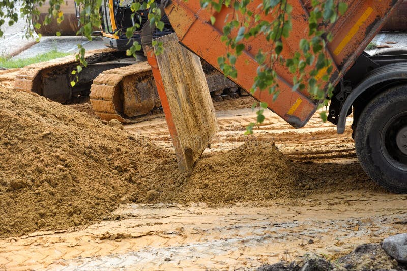 A Dump Truck Dumping Sand at a Construction Site Stock Photo - Image of ...