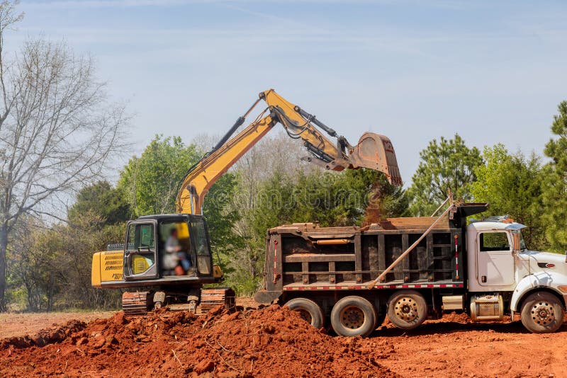 A Dump Truck is Loading Earth into an Excavator on a Construction Site ...