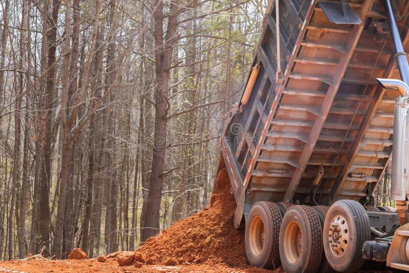 Dump Truck is Moving Down Soil Leveling the Ground on Construction Site ...