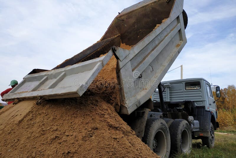 A Dump Truck Unloads Sand at a Construction Site To Mix Cement Stock ...
