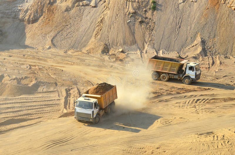Dump Trucks Transports Sand in an Open Pit. View of the Quarry Where ...