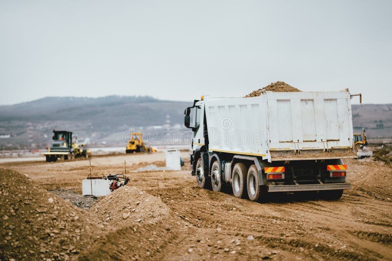 Industrial Dumper Trucks Working on Highway Construction Site, Loading ...