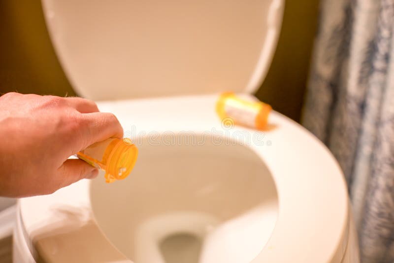 Dumping Medication Pills from a Plastic Bottle into an Open Toilet ...
