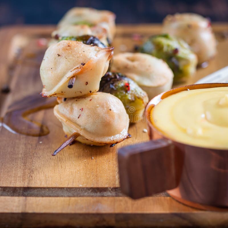 Dumplings and Brussels Sprouts on Skewers with Cheese Sauce Stock Image ...