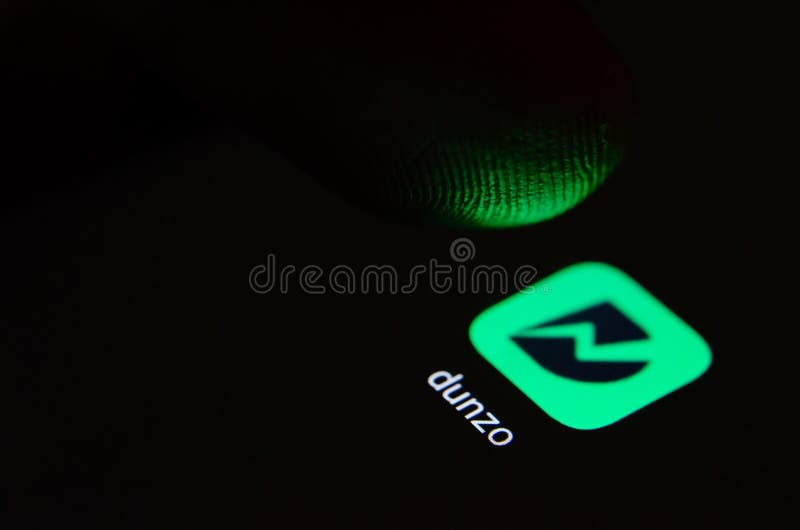 Dunzo Delivery App Logo Glowing on the Screen in a Dark Room and Finger ...