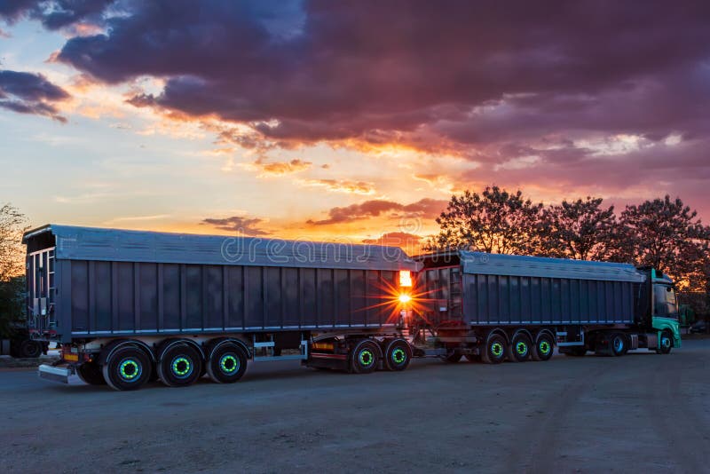 Duo-trailer with Tippers for Scrap Metal Parked at Sunset, Under a ...
