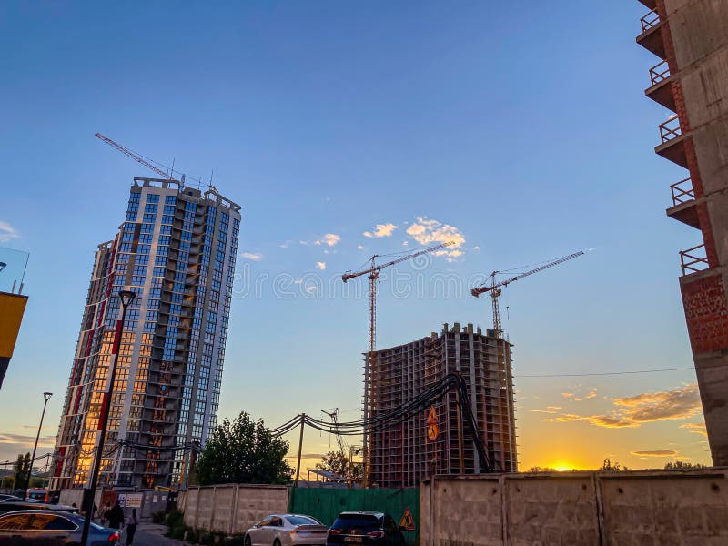 A Dusk-lit Construction Site with Three Buildings Under Construction ...