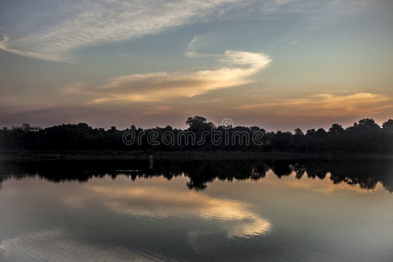 Dusk Time Shot of Sunset through a Lake with Trees and Clouds. Stock ...