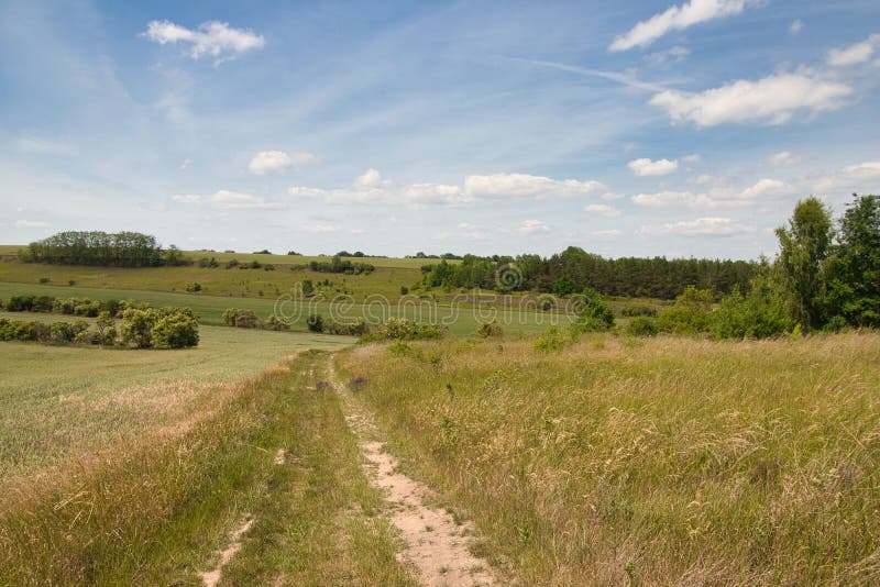 A Dusty Path Around Field in Spring Day Under Blue Sky with Clouds ...
