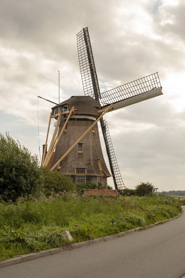 Dutch Windmill with Enormous Mill Blades Around the Corner of the Road ...