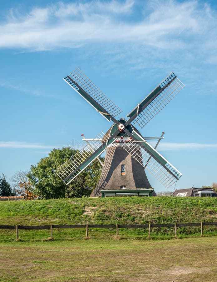 Dutch Windmill on a Green Hill, with a Bright Blue Sky Stock Photo ...
