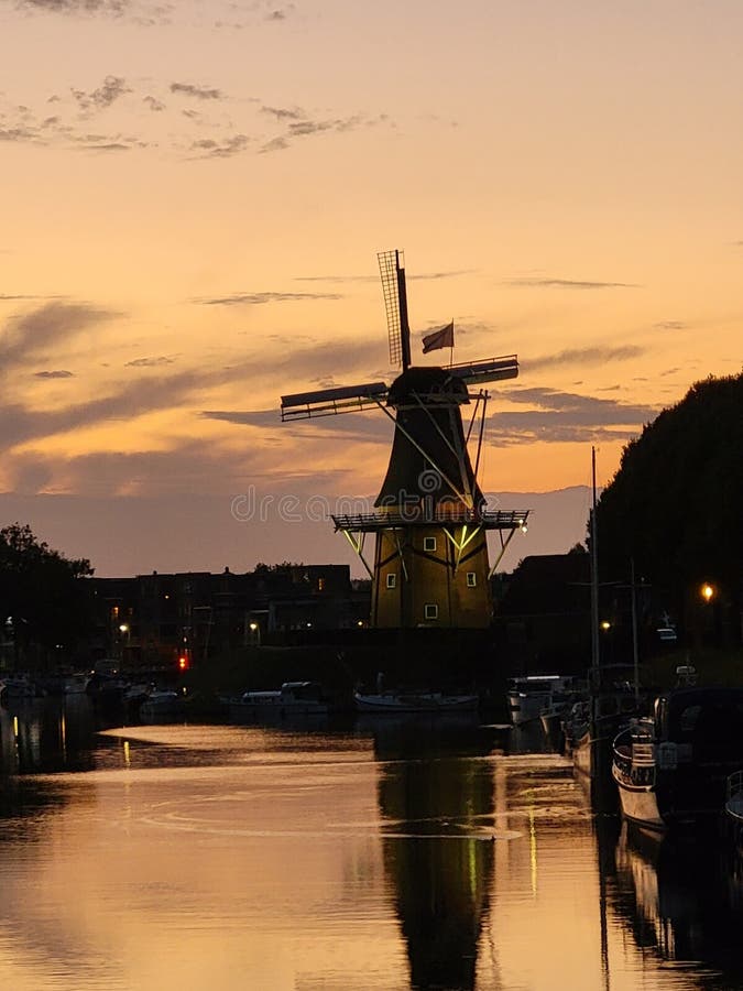 Windmill sunset at a lake stock photo. Image of meteorology - 238779682