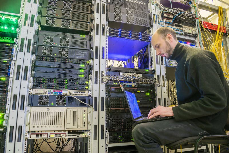 The on-duty Engineer with the Laptop Works in the Server Room. the ...