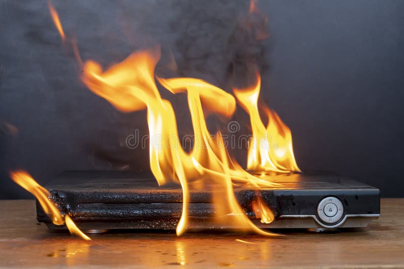 A DVD Player is Burning on the Table, Flames are Rising Up, the Case ...