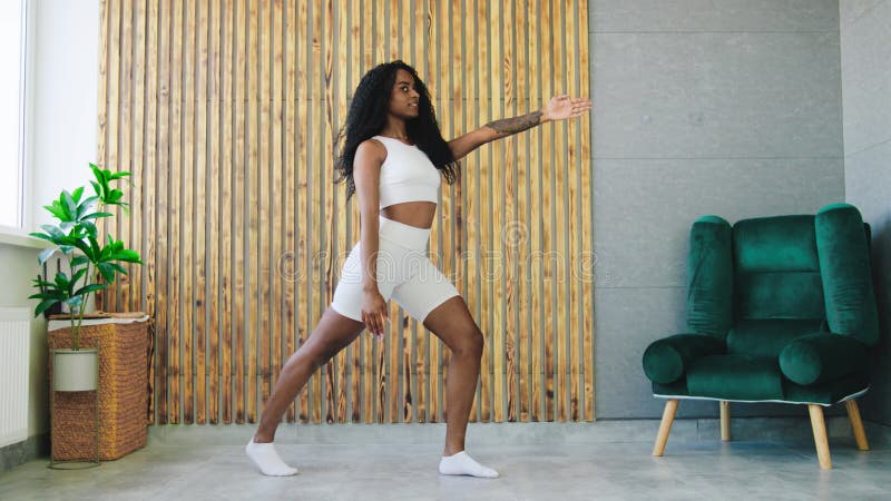 A Dynamic Exercise Pose Set in a Modern Indoor Space Offers a Blend of ...