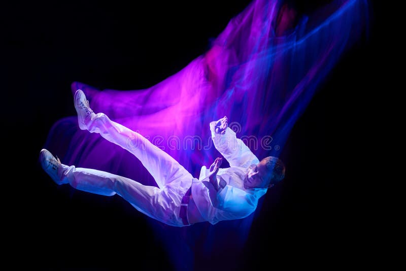 Dynamic Image of Young Man in Casual Clothes Falling Down Against Black ...