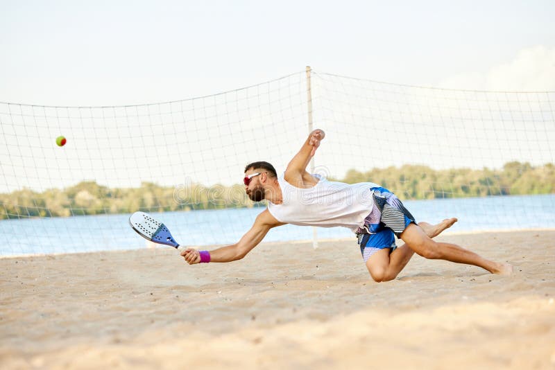 Dynamic Image of Young Man Playing Beach, Paddle Tennis, Hitting Ball ...