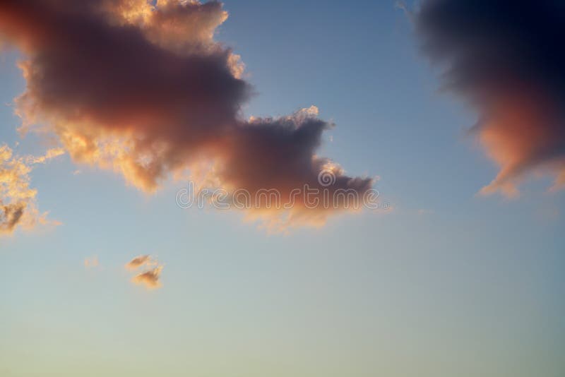 Dynamic Pink and Gold Clouds Float Across Blue Sky Stock Image - Image ...
