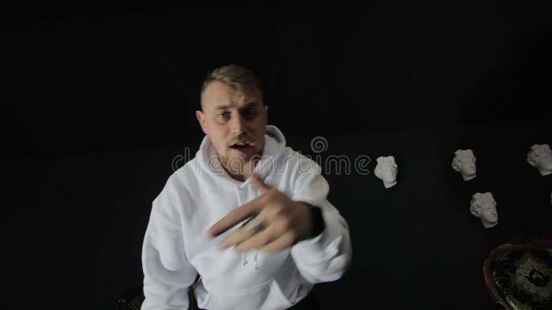 Dynamic Rapper Gesturing in Studio, a Man in a White Hoodie Gestures ...
