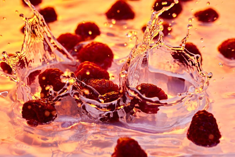 Dynamic Splash of Raspberry Hitting Water, with Scattered Berries in ...